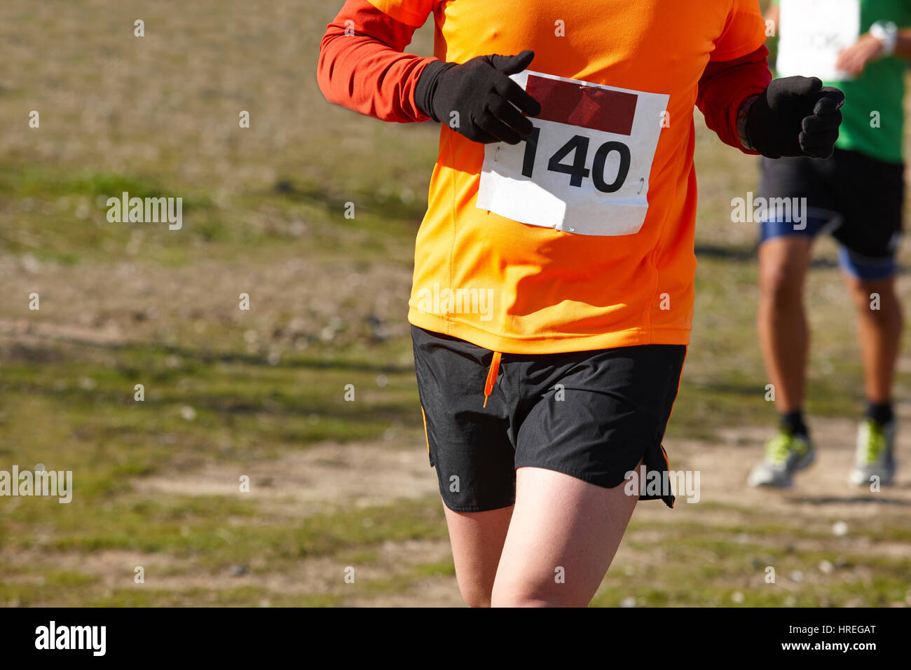 Male athletic runners on a cross country race. Outdoor circuit ...
