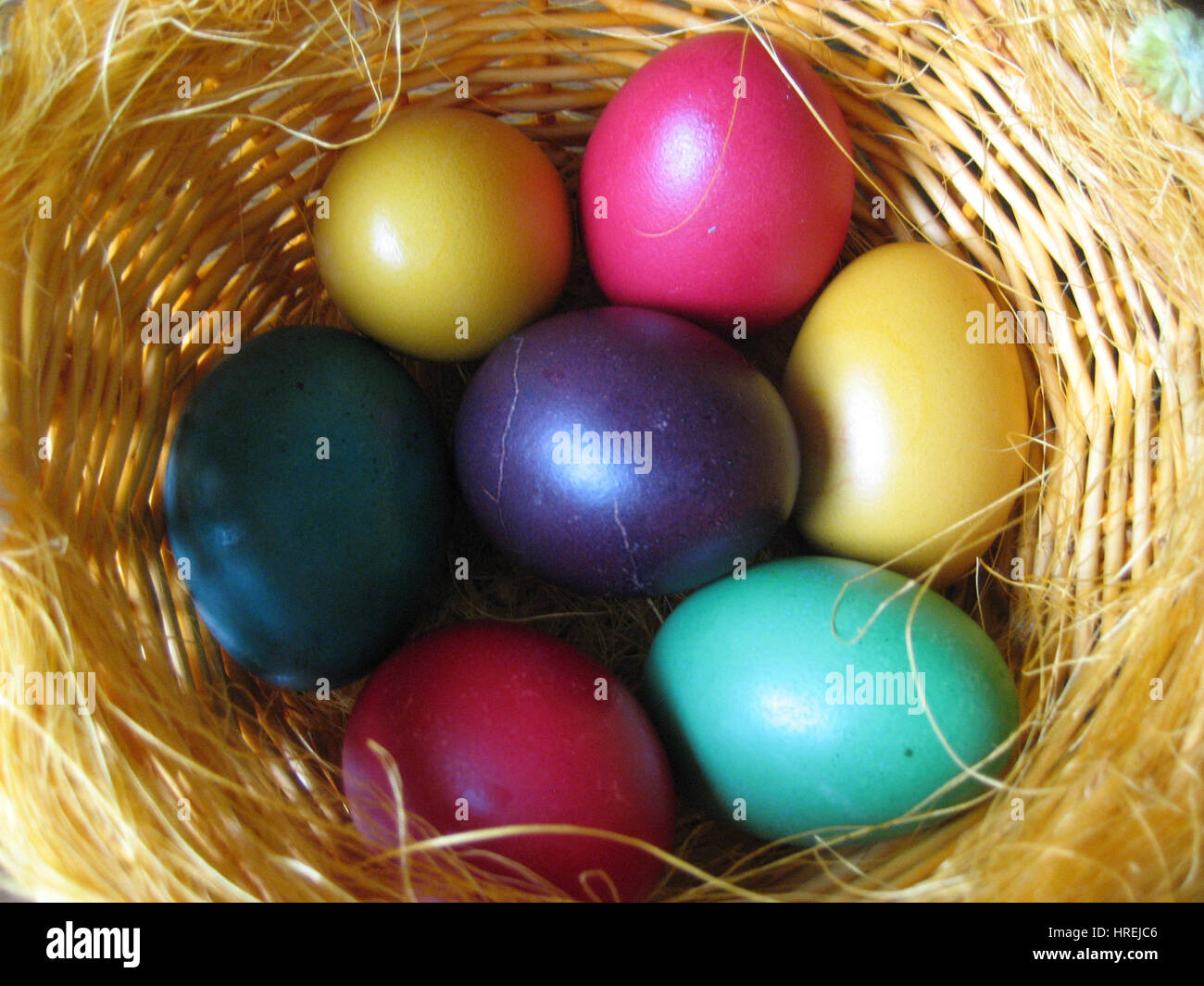Colored easter eggs in basket Stock Photo - Alamy