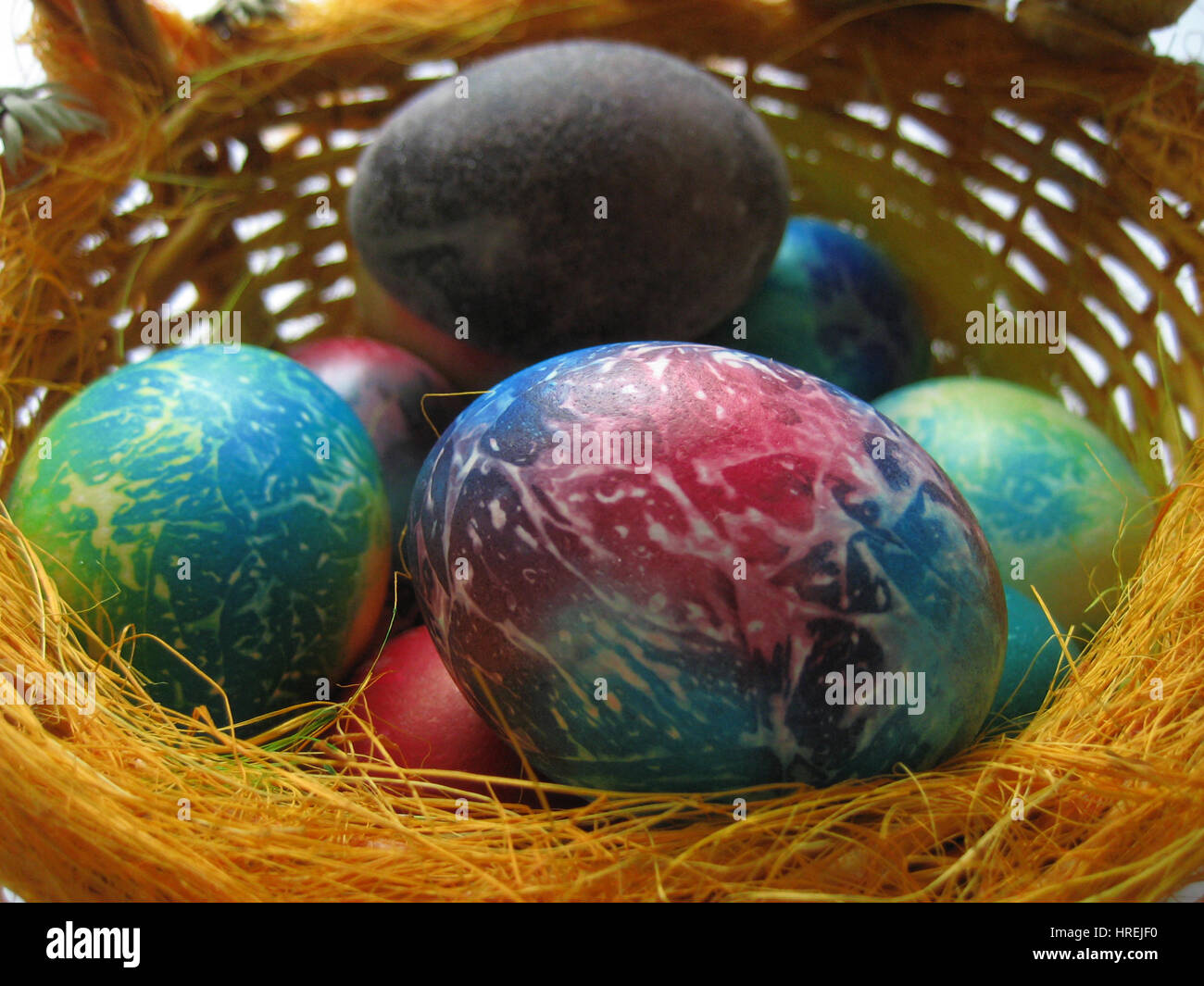 Colored easter eggs in basket Stock Photo - Alamy