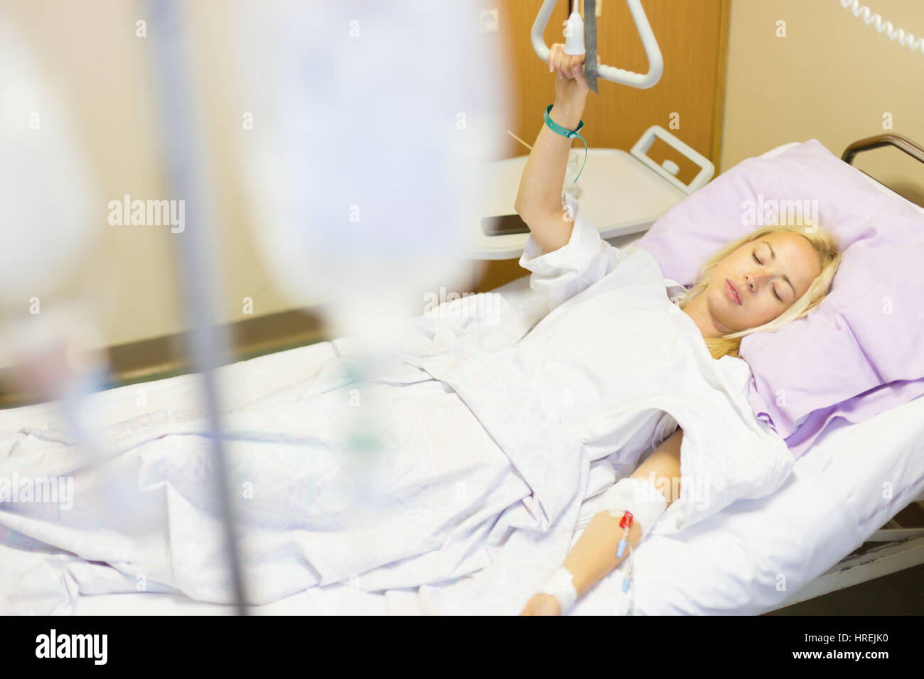 Bedridden female patient lying in hospital bed, recovering after ...