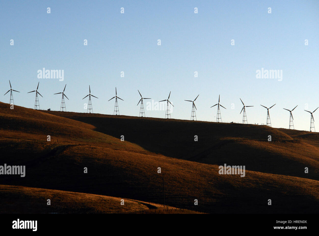 Wind turbines and power transmission lines at sunset near San Francisco ...