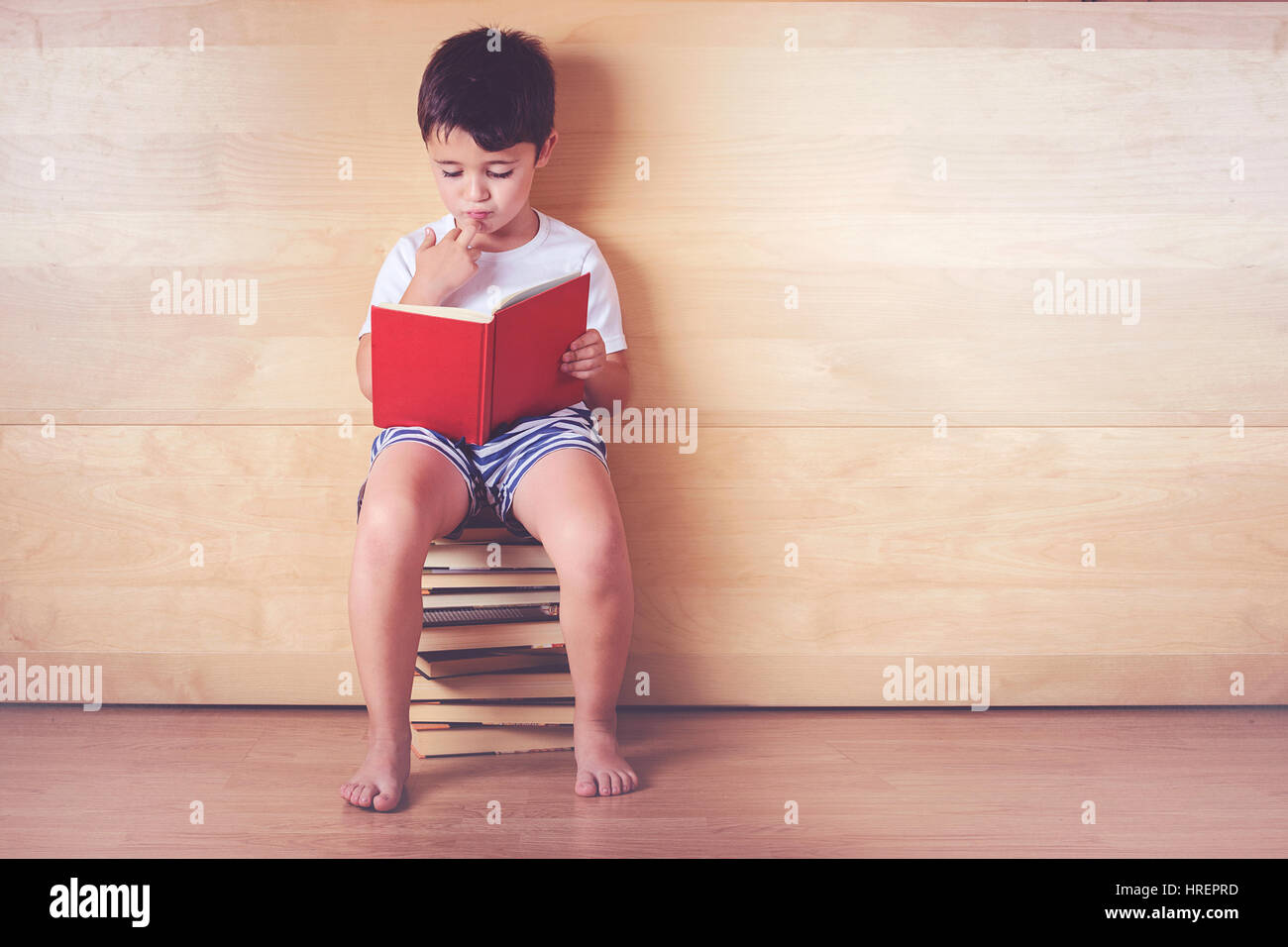 Boy reading a book Stock Photo - Alamy