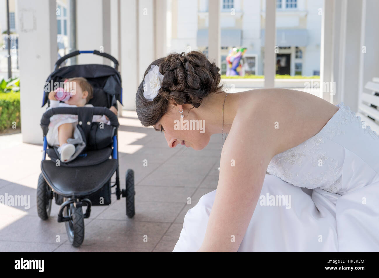 Beautiful bride in a white dress and her little child Stock Photo - Alamy