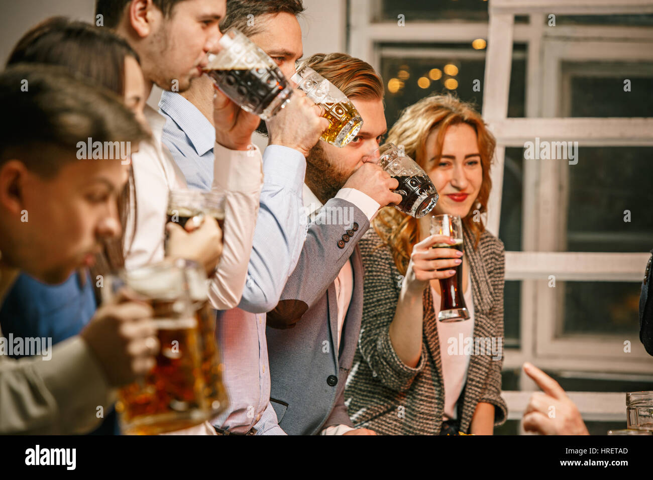 Group of friends enjoying evening drinks with beer on wooden table ...