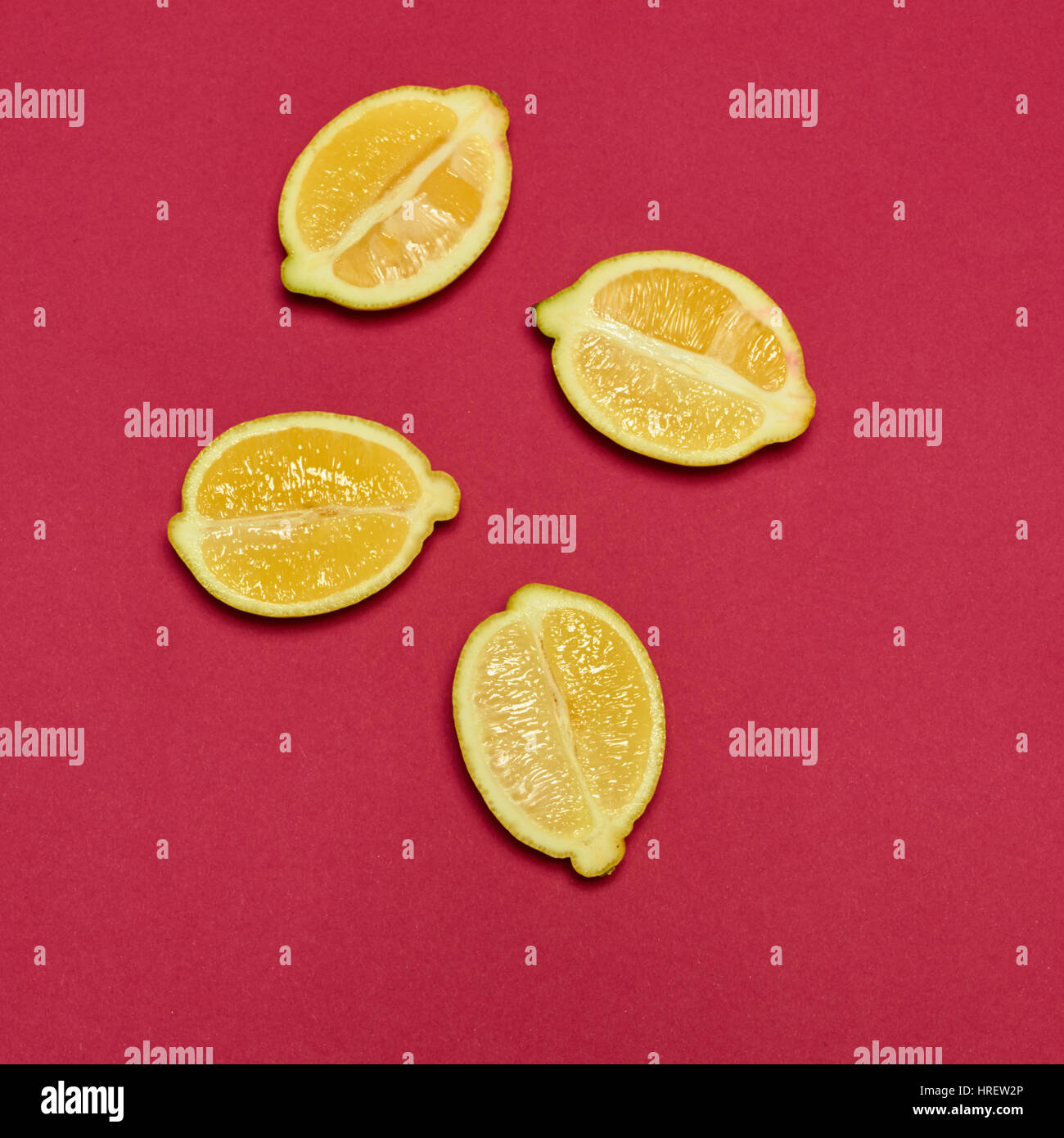 The fresh lemons cut in half on red background Stock Photo - Alamy