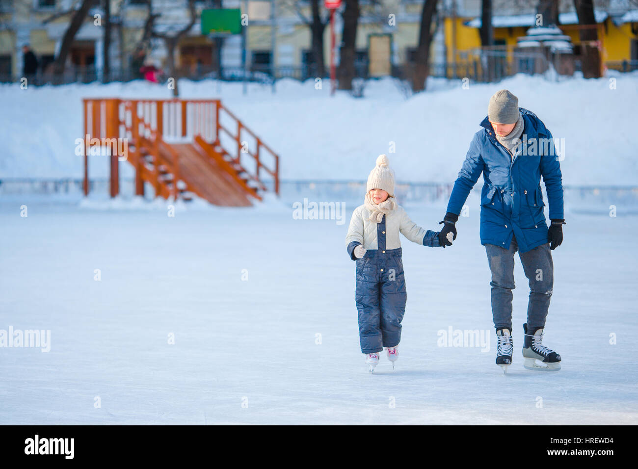 Young dad and adorable little girl have fun on skating rink Stock Photo ...