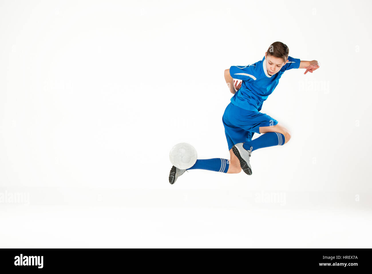 Young boy with soccer ball doing flying kick, isolated on white Stock ...