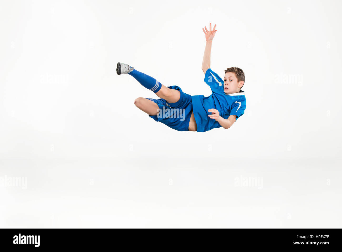 Young boy with soccer ball doing flying kick, isolated on white Stock ...