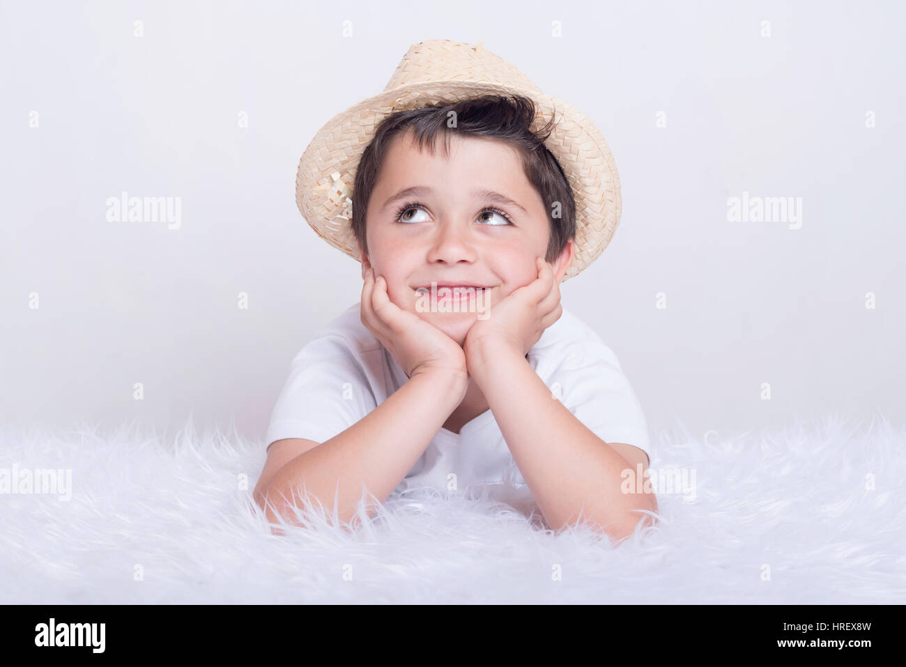 Funny child. Little boy thinking lying on bed Stock Photo - Alamy