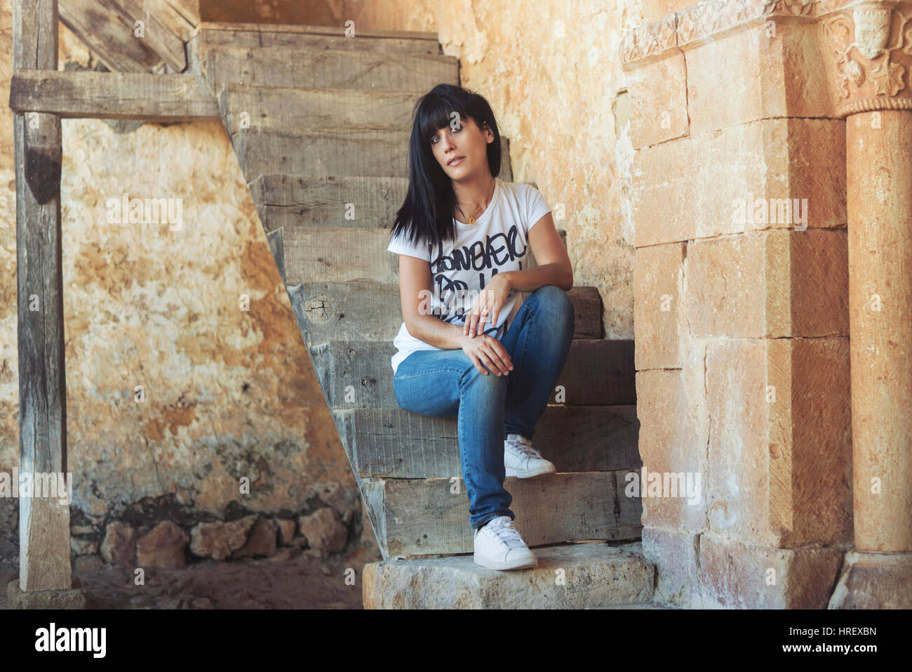 girl sitting on stairs near old grungy wall Stock Photo - Alamy