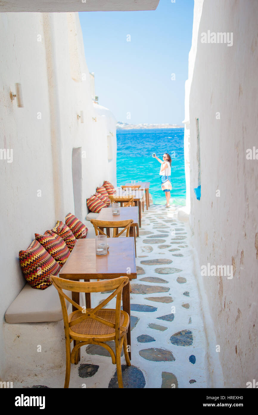Benches with pillows in a typical Greek bar in Mykonos town with sea ...
