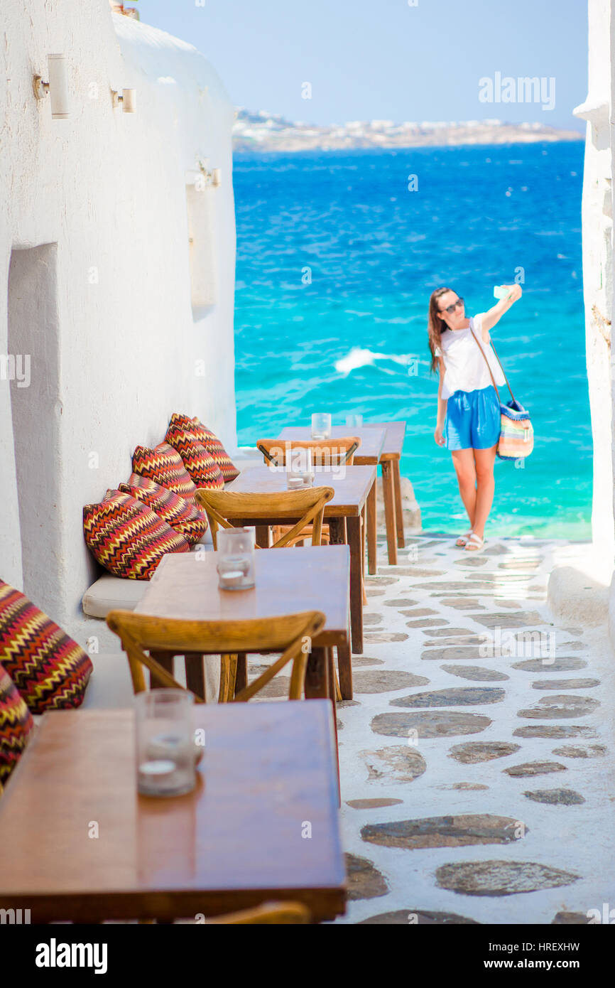 Benches with pillows in a typical Greek bar in Mykonos town with sea ...