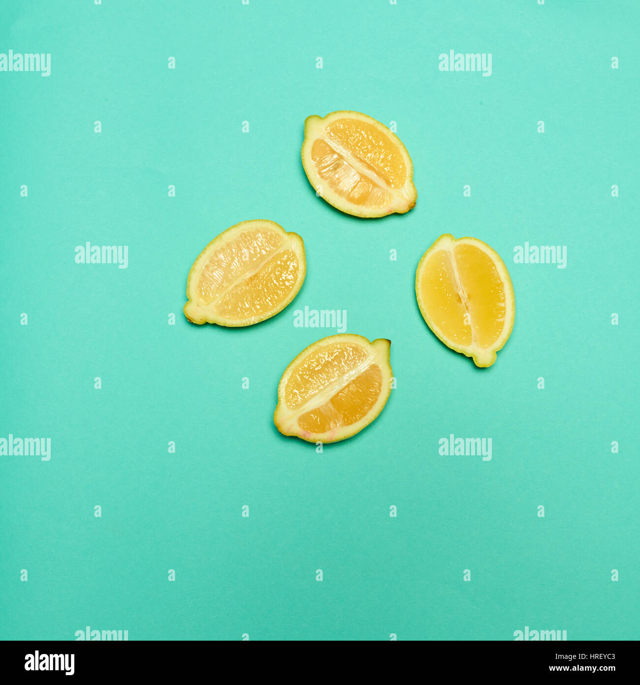 The fresh lemons cut in half on green background Stock Photo - Alamy