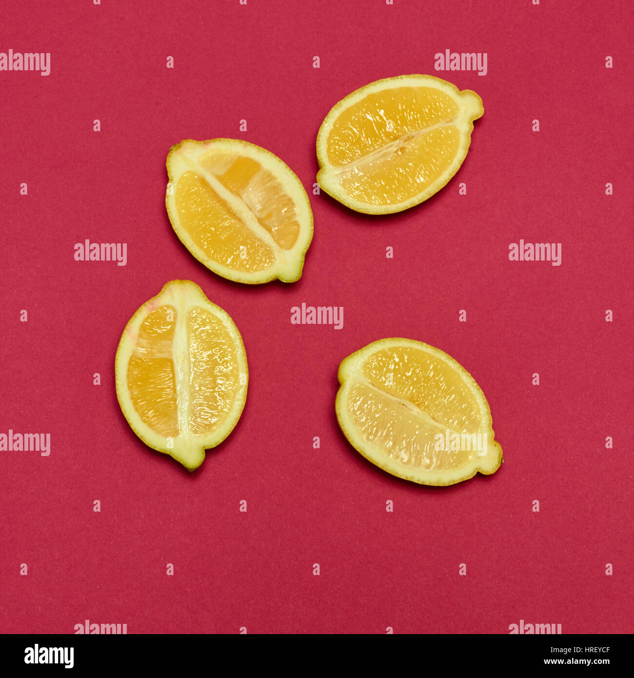 The fresh lemons cut in half on red background Stock Photo - Alamy