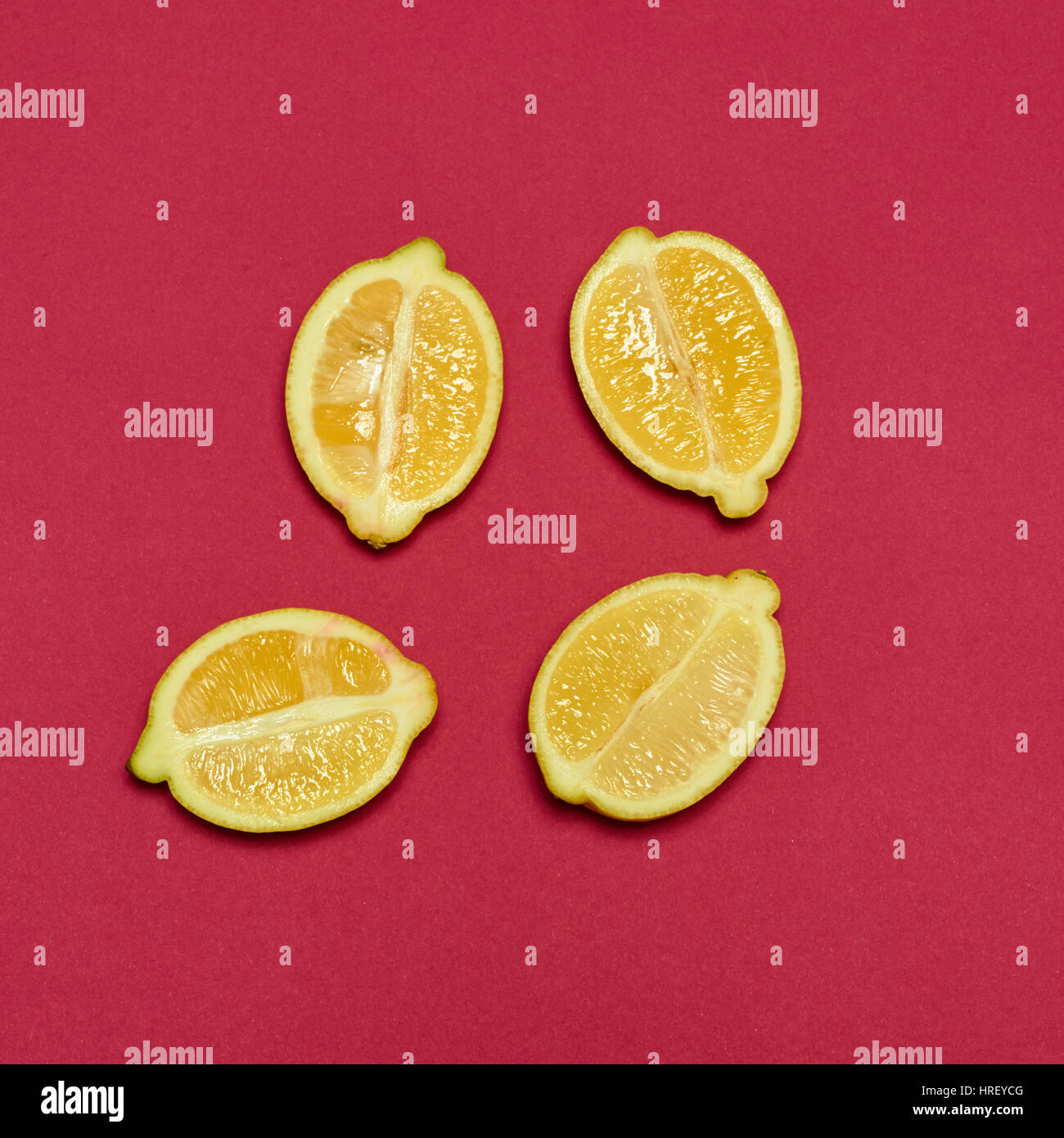 The fresh lemons cut in half on red background Stock Photo - Alamy