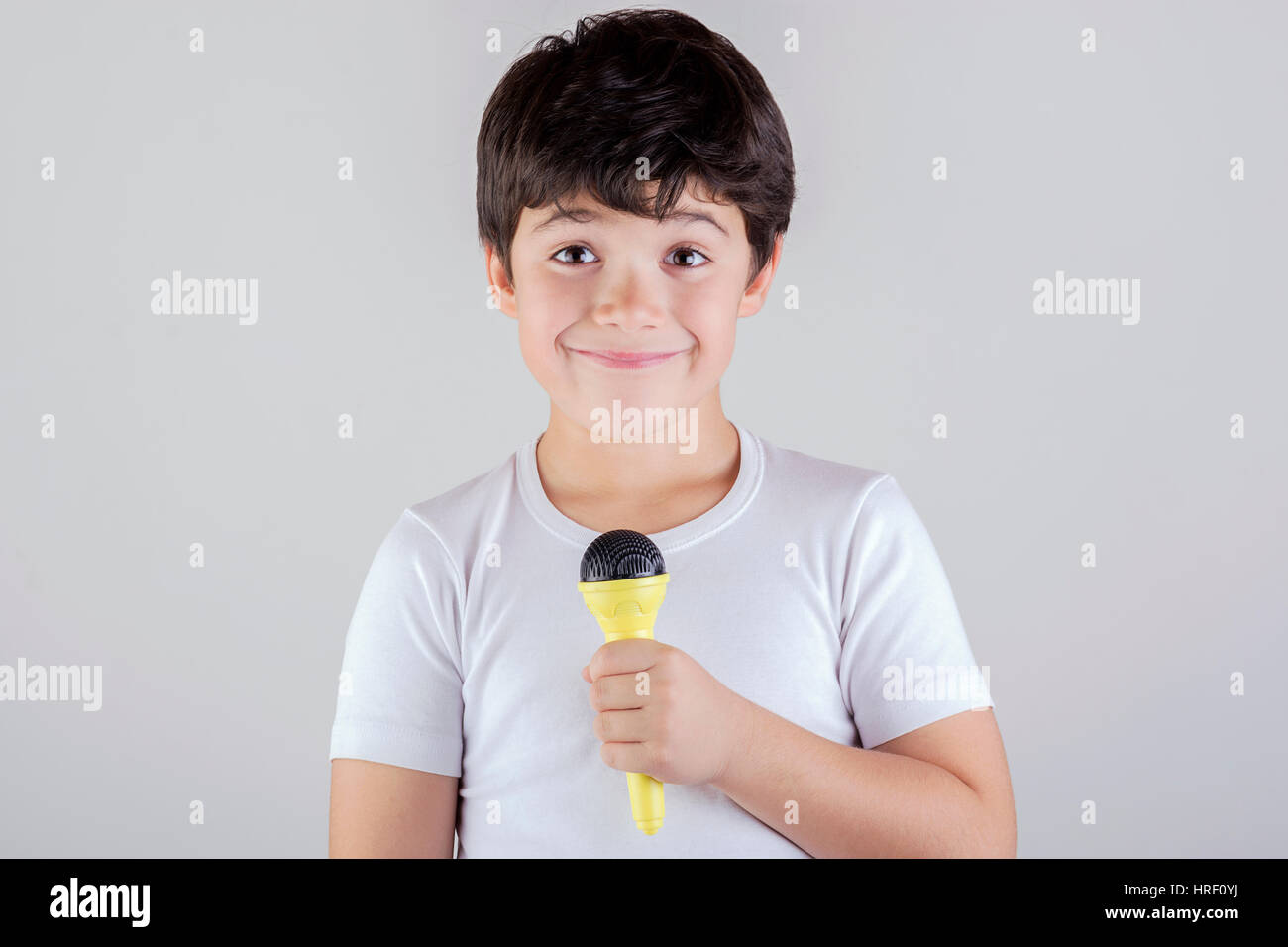 Boy singing to microphone Stock Photo - Alamy