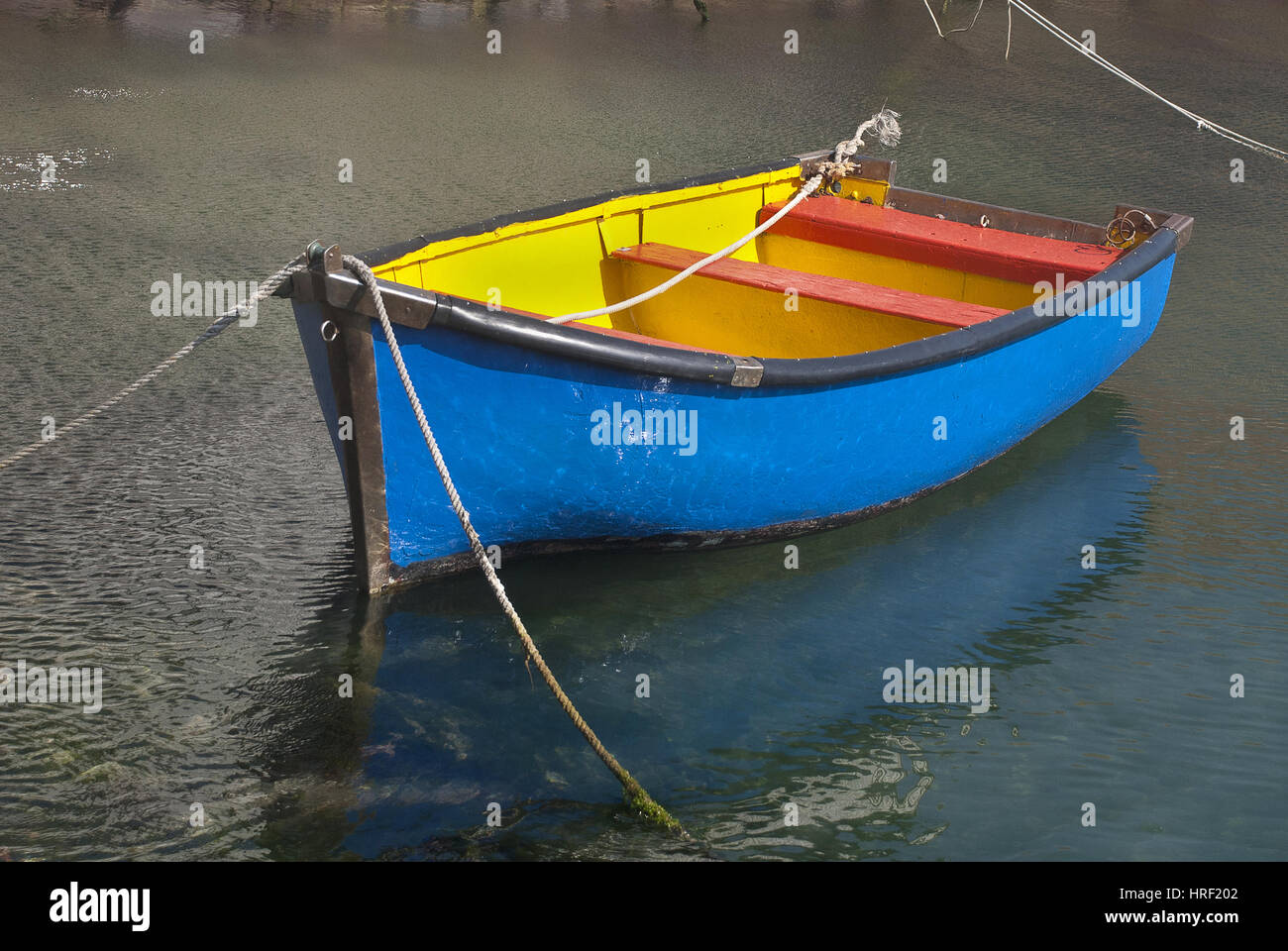 A blue and yellow rowing boat moored in a harbour, South Africa Stock ...