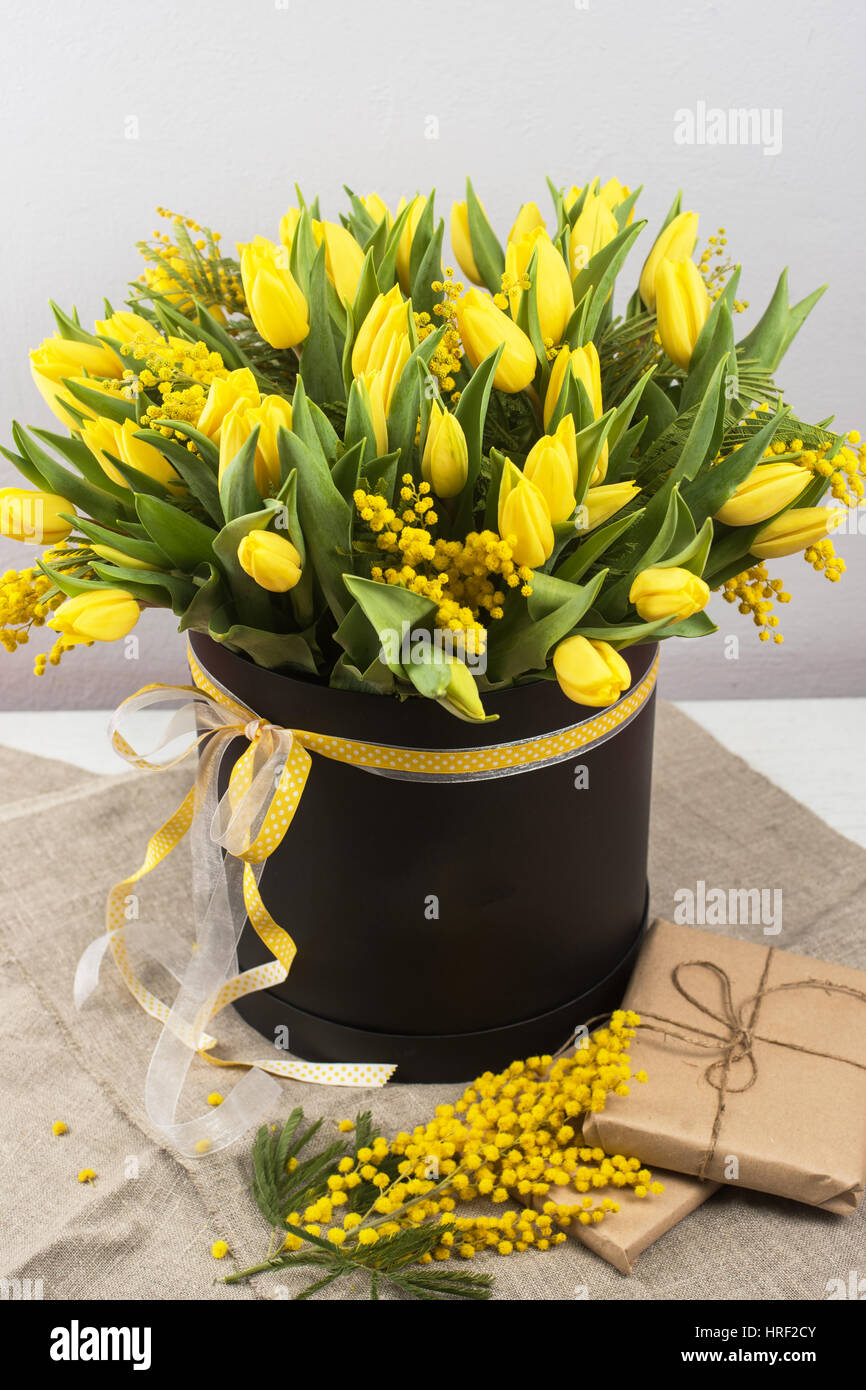 Bright spring bouquet of tulips and mimosa flowers. Mother's Day or ...