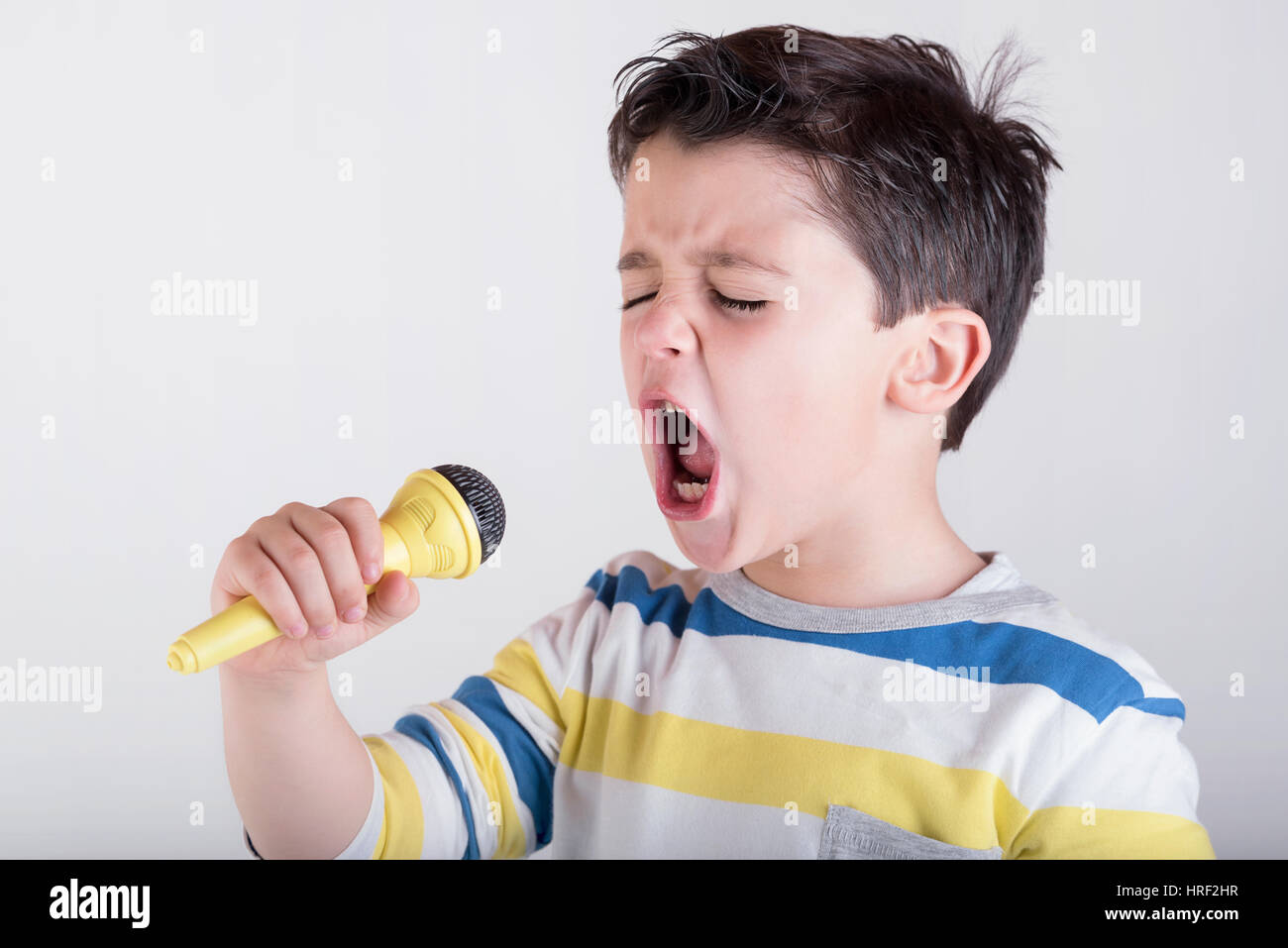 Boy singing to microphone Stock Photo - Alamy