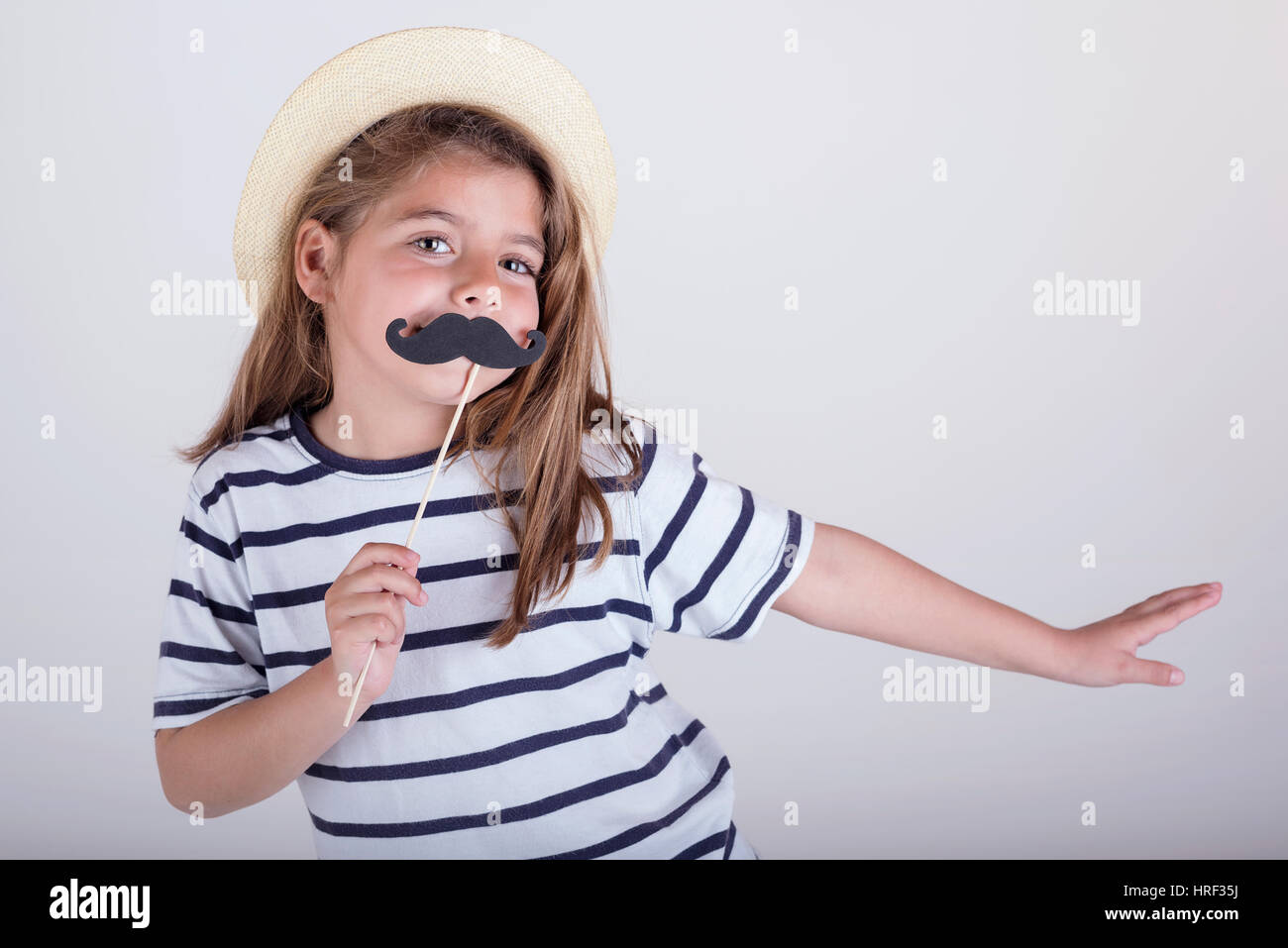 Beautiful cute little girl playing with mustache Stock Photo - Alamy