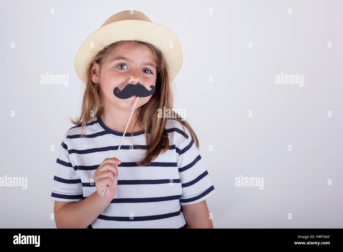 Beautiful cute little girl playing with mustache Stock Photo - Alamy
