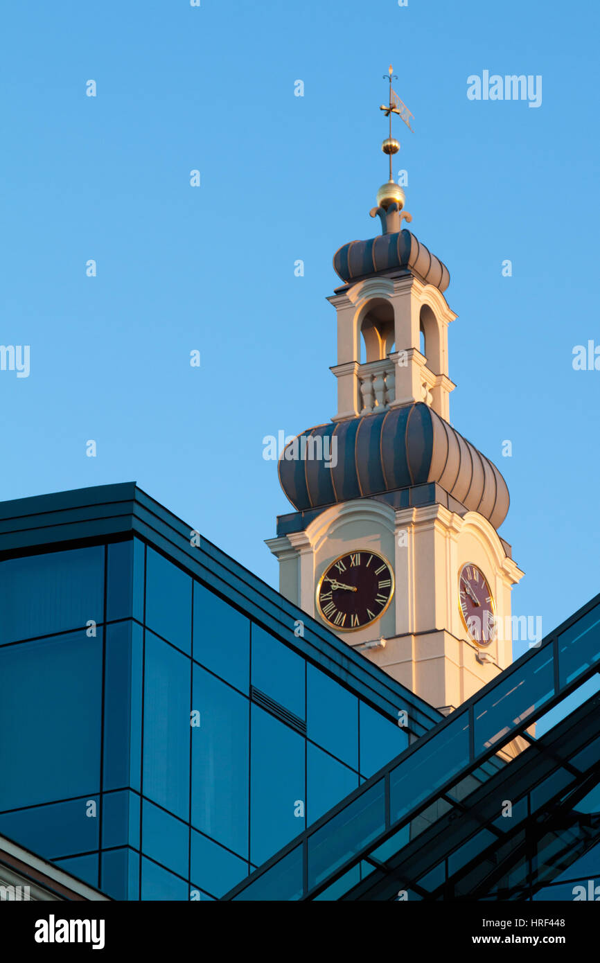 Old clock tower behind modern glass buinding Stock Photo - Alamy
