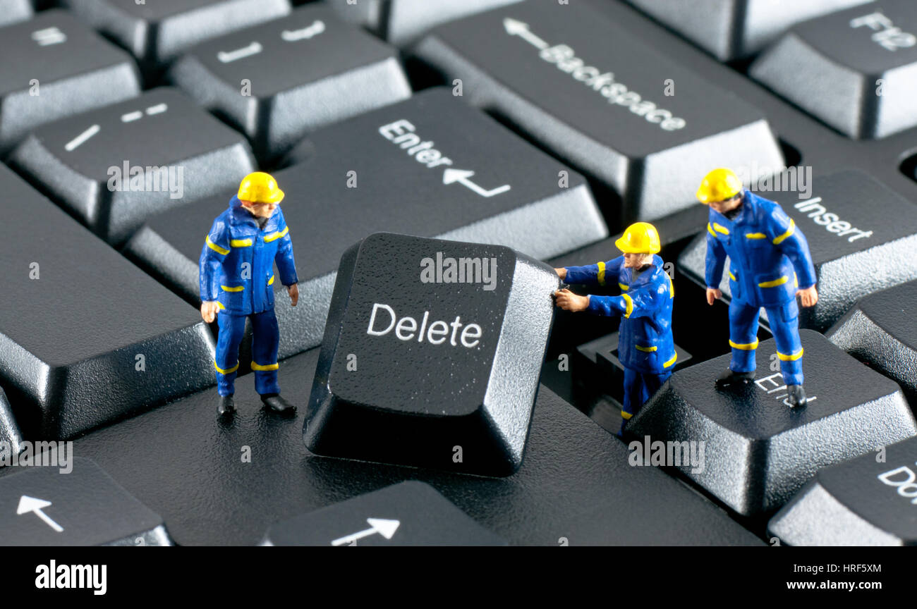 Team of construction workers working with DELETE button on a computer ...