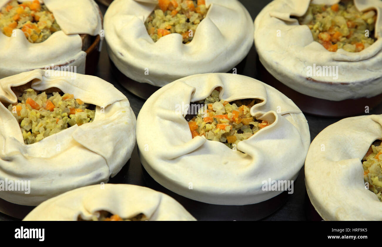 Individual beef and vegetable pies, ready to cook in a commercial ...