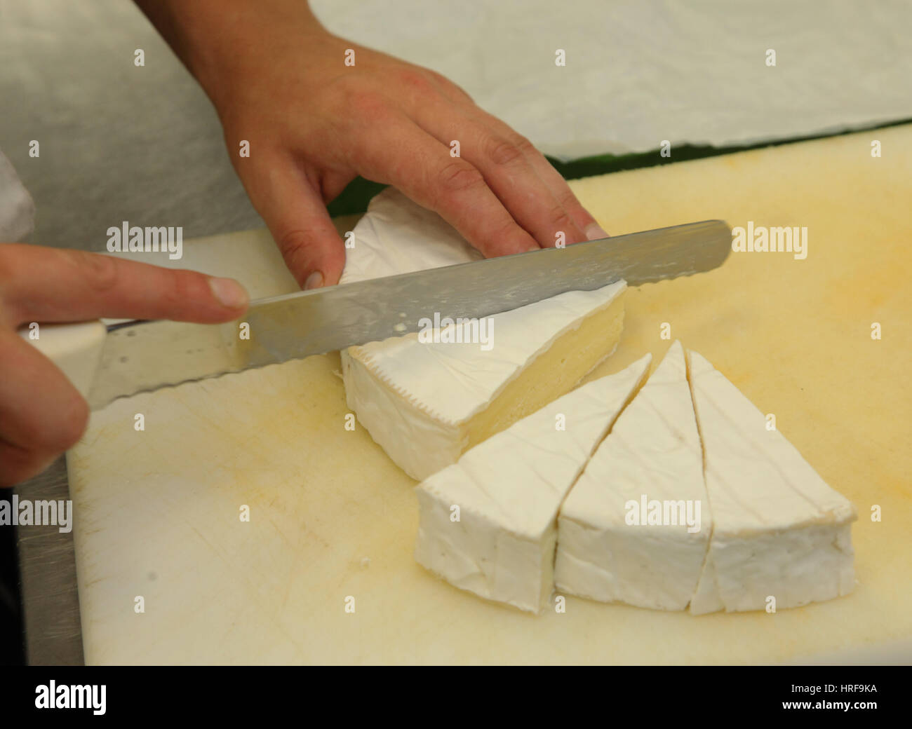 Cutting slices of brie cheese Stock Photo - Alamy