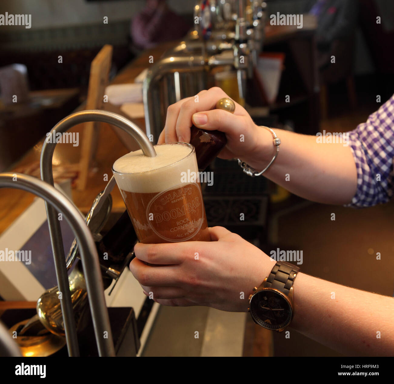 Barmaid pulling a pint of beer, Sharps Doombar, in a pub Stock Photo ...