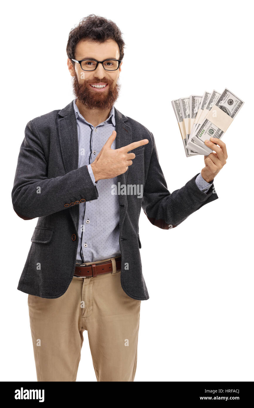 Young man holding bundles of money and pointing isolated on white ...