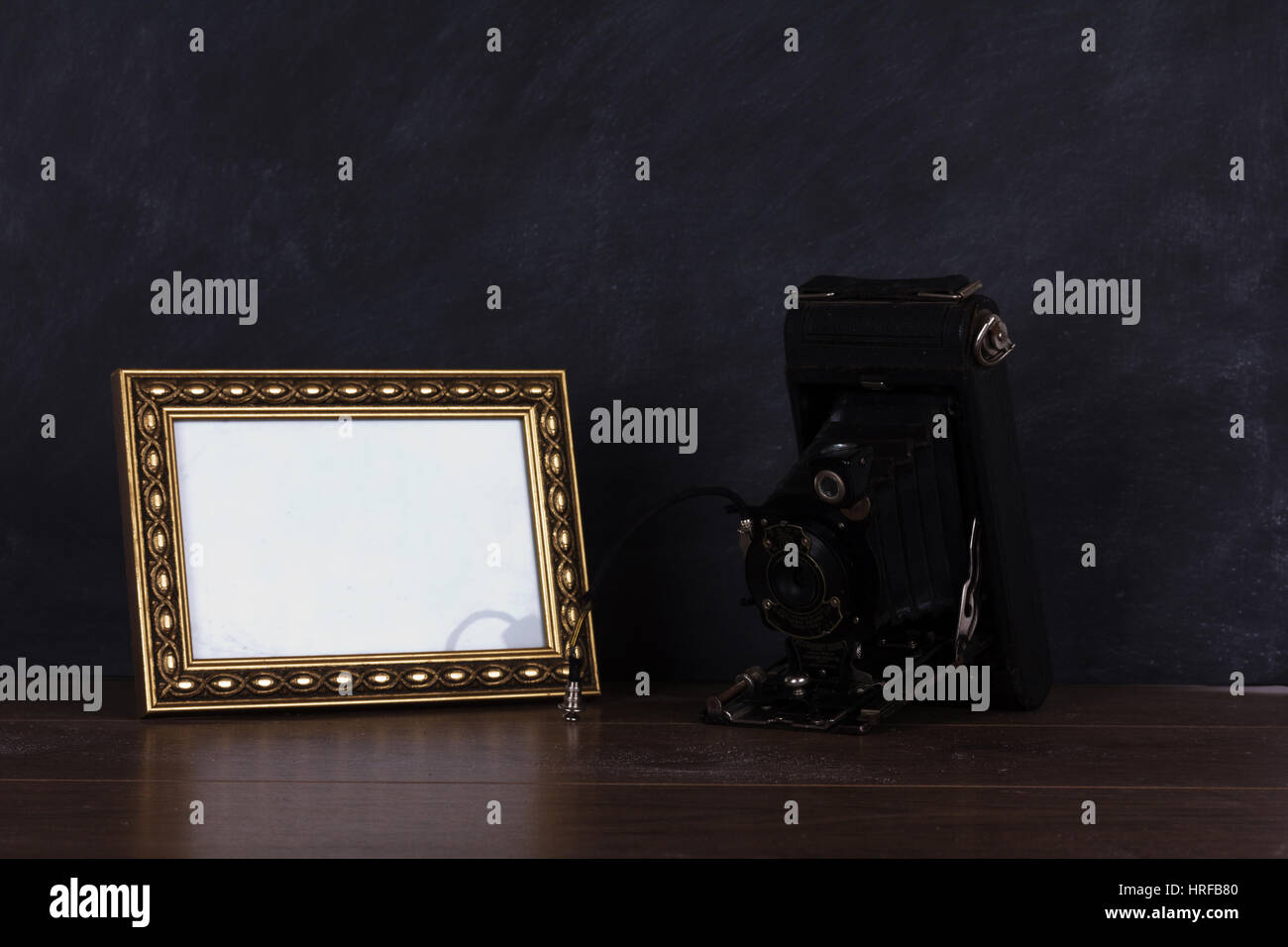 Old vintage camera and frame against blackboard background Stock Photo ...