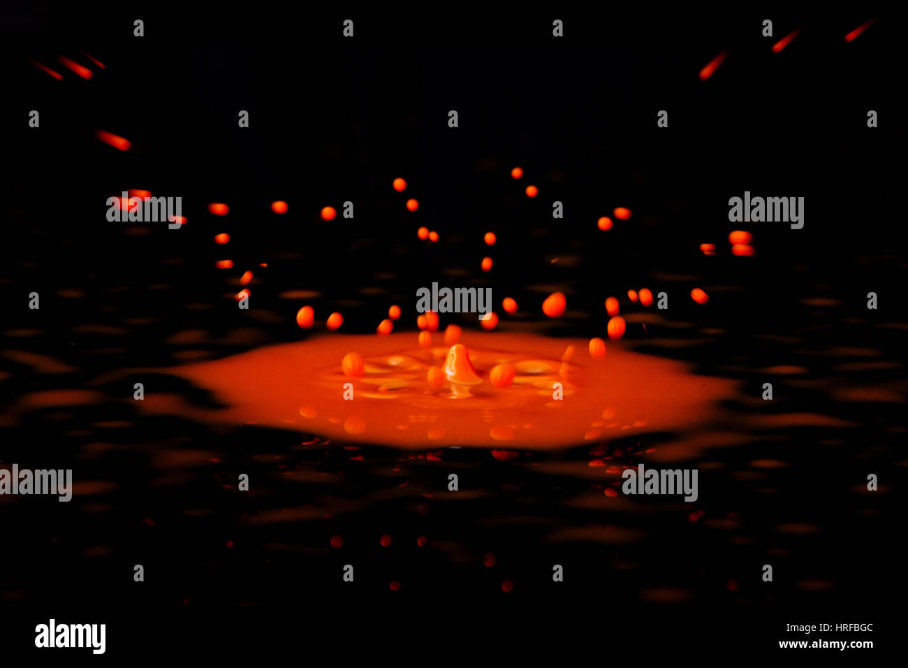 Colorful paint drop splashing on black a background Stock Photo - Alamy