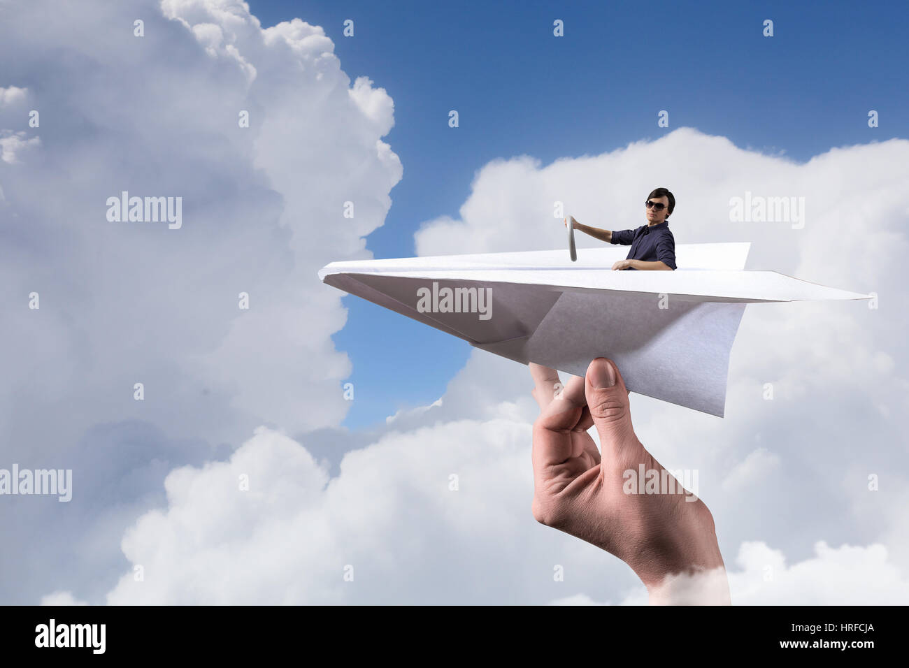 Businessman is flying on paper airplane high in sky Stock Photo - Alamy