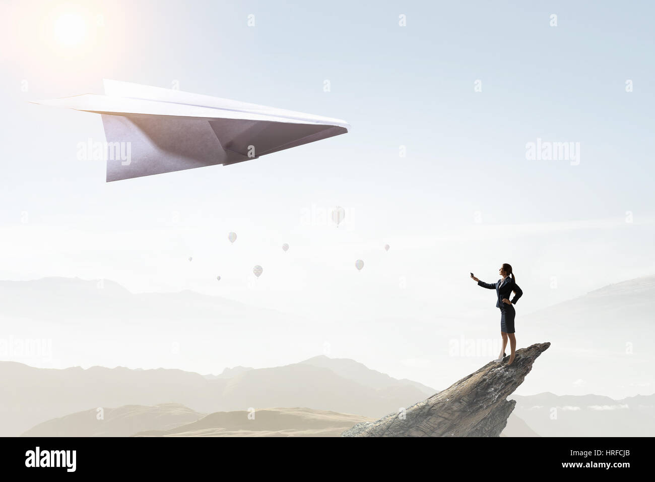 Elegant businesswoman and big paper plane flying in sky. Mixed media ...