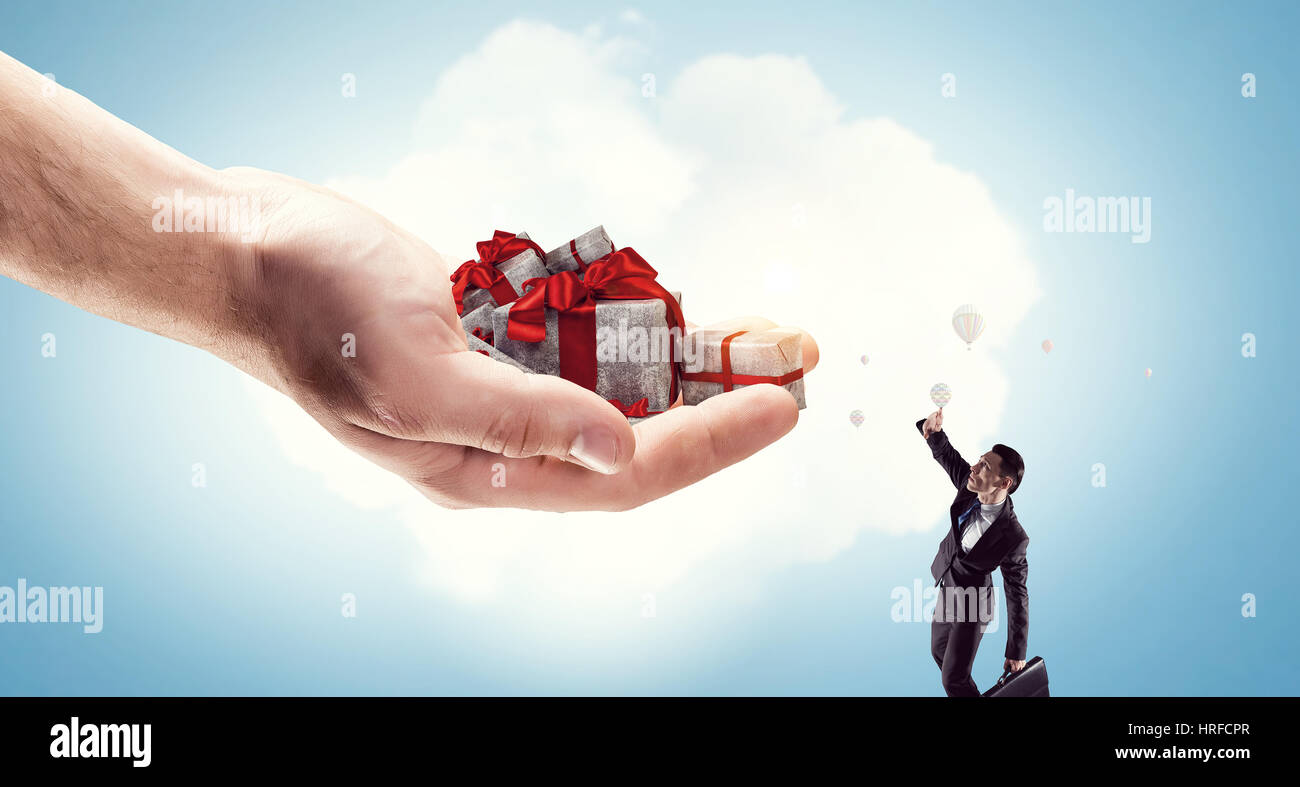 Young businessman and hand giving him gift box Stock Photo - Alamy