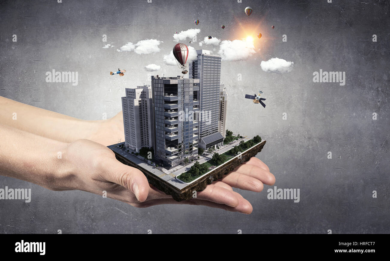 Close of human hand showing modern city model. Mixed media Stock Photo ...