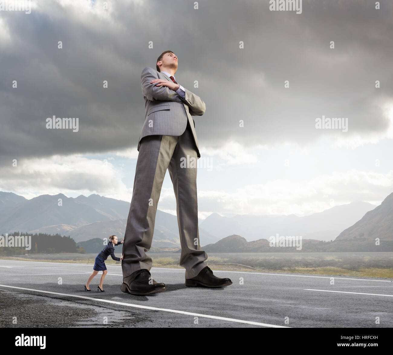 Giant businessman with long legs standing on road Stock Photo - Alamy