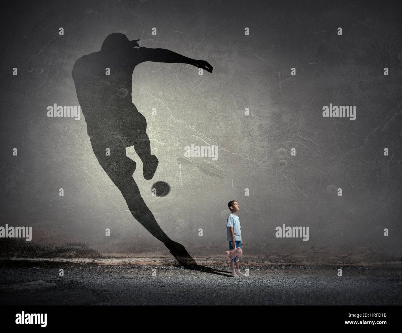 Kid boy in empty room dreaming to become football player Stock Photo ...
