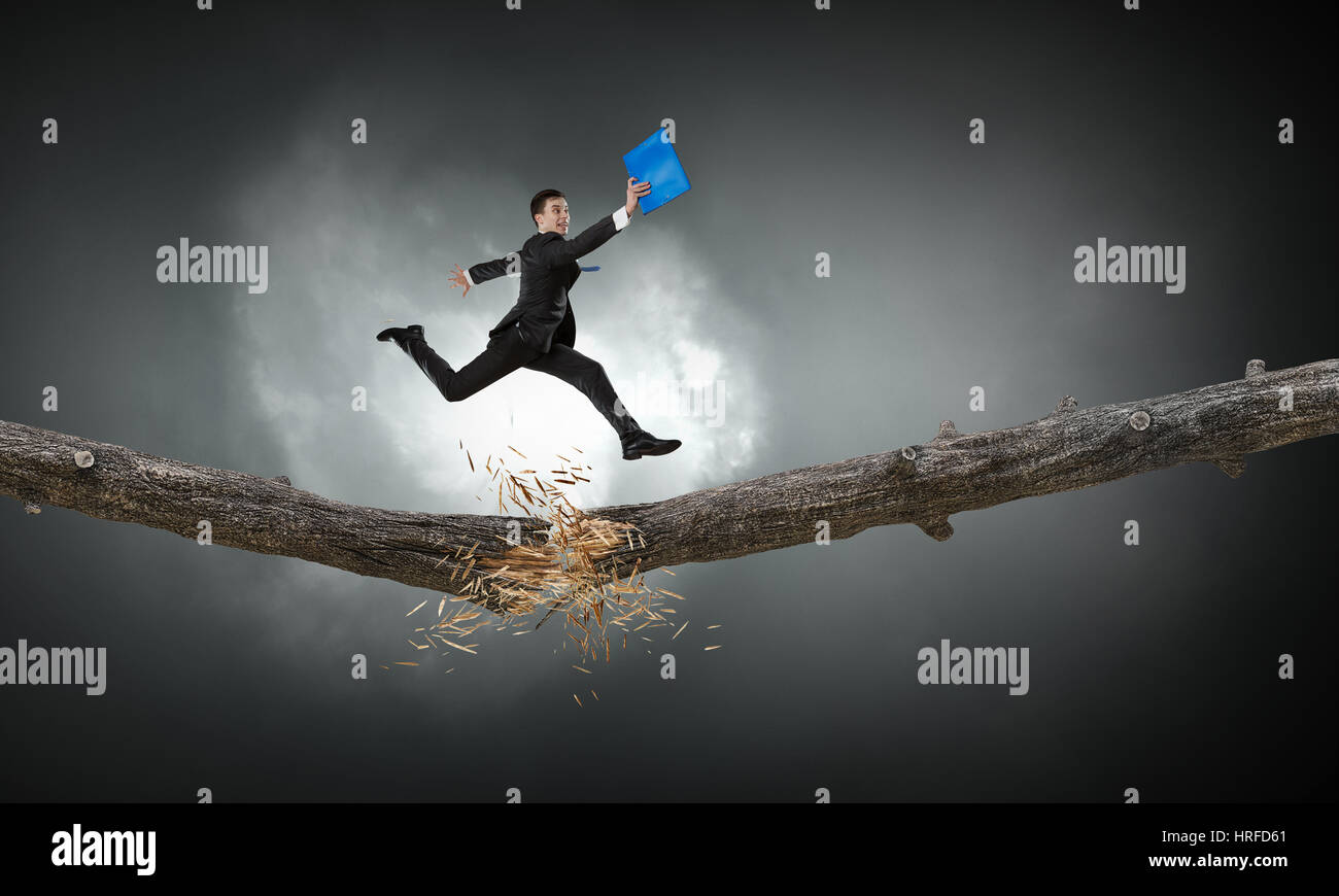Businessman running on broken wooden log above gap. Mixed media Stock ...