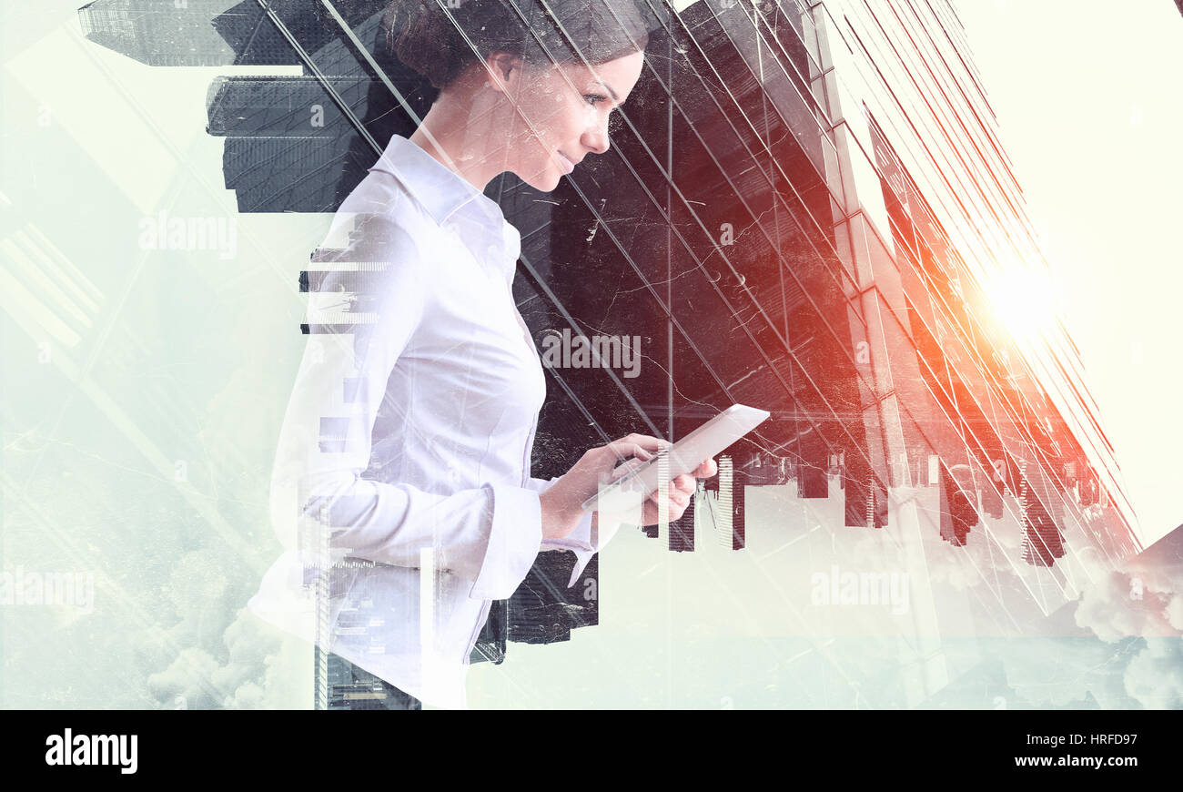 Attractive businesswoman using tablet pc against modern city background ...