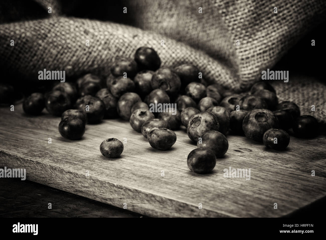 Blueberries spilt over a rustic wooden background Stock Photo - Alamy