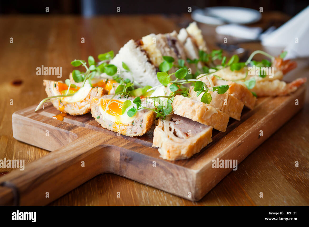 Scotch egg on platter, served on a wooden chopping board Stock Photo ...