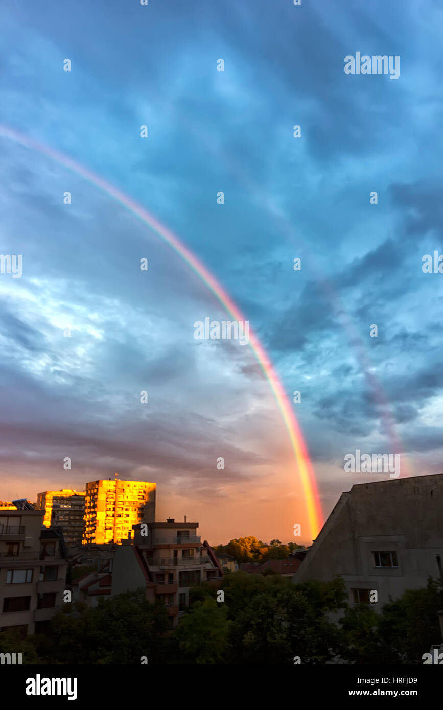 Photo of bright colorful rainbow over city, beautiful colors phenomenon ...