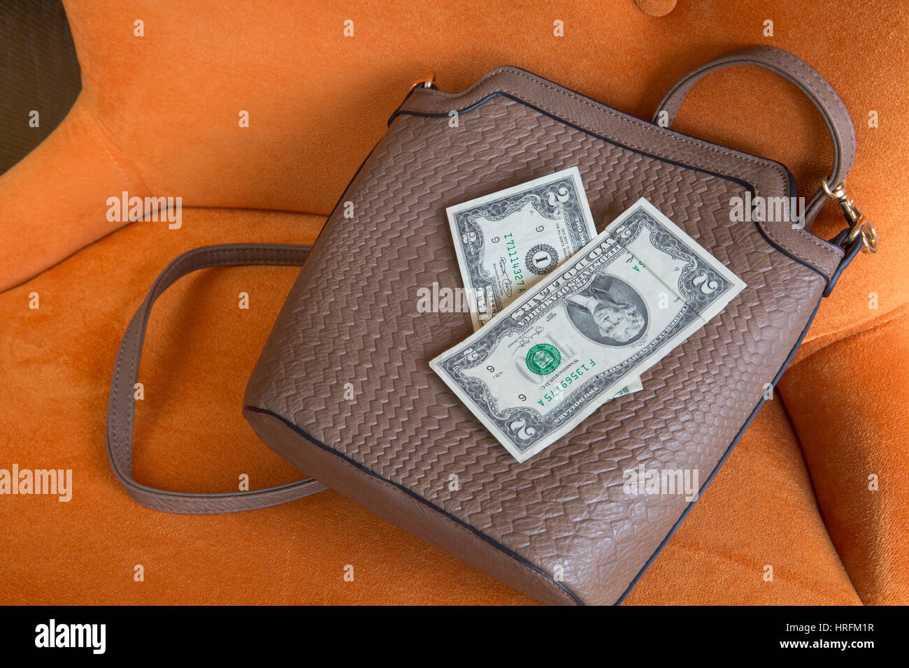 Dollar bills on top of a handbag Stock Photo - Alamy