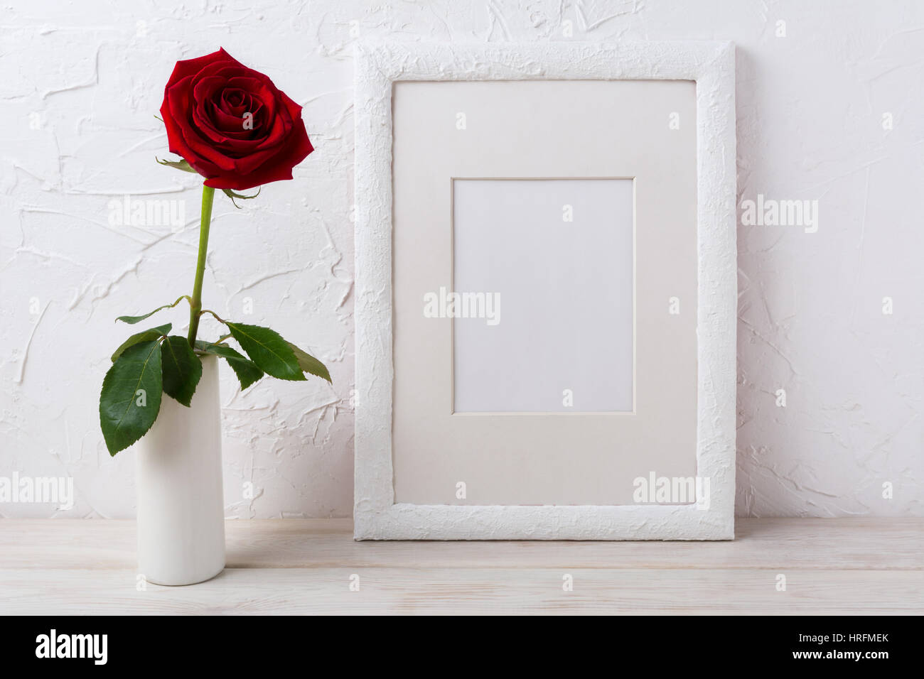 White frame mockup with dark red rose in vase. Empty frame mock up for ...