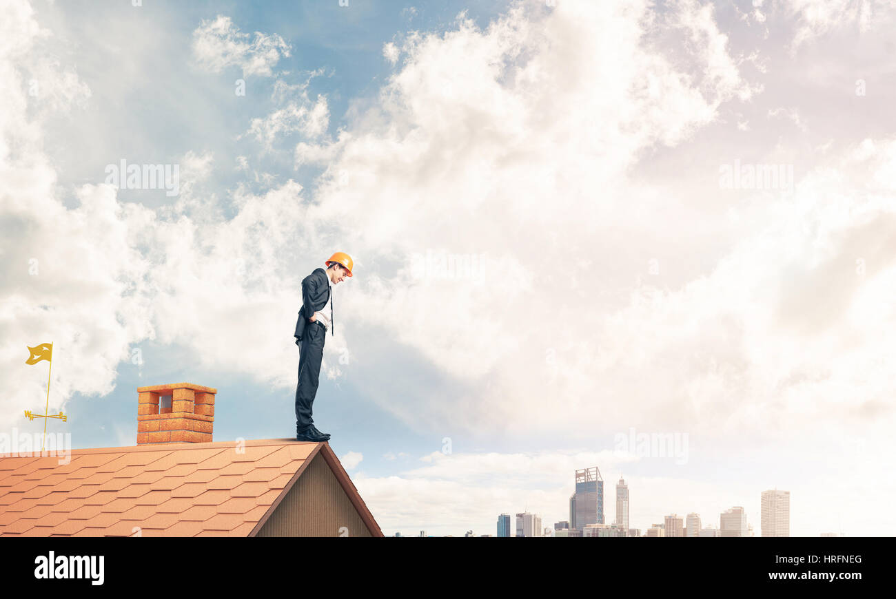 Businessman looking down from roof and modern cityscape at backg Stock ...