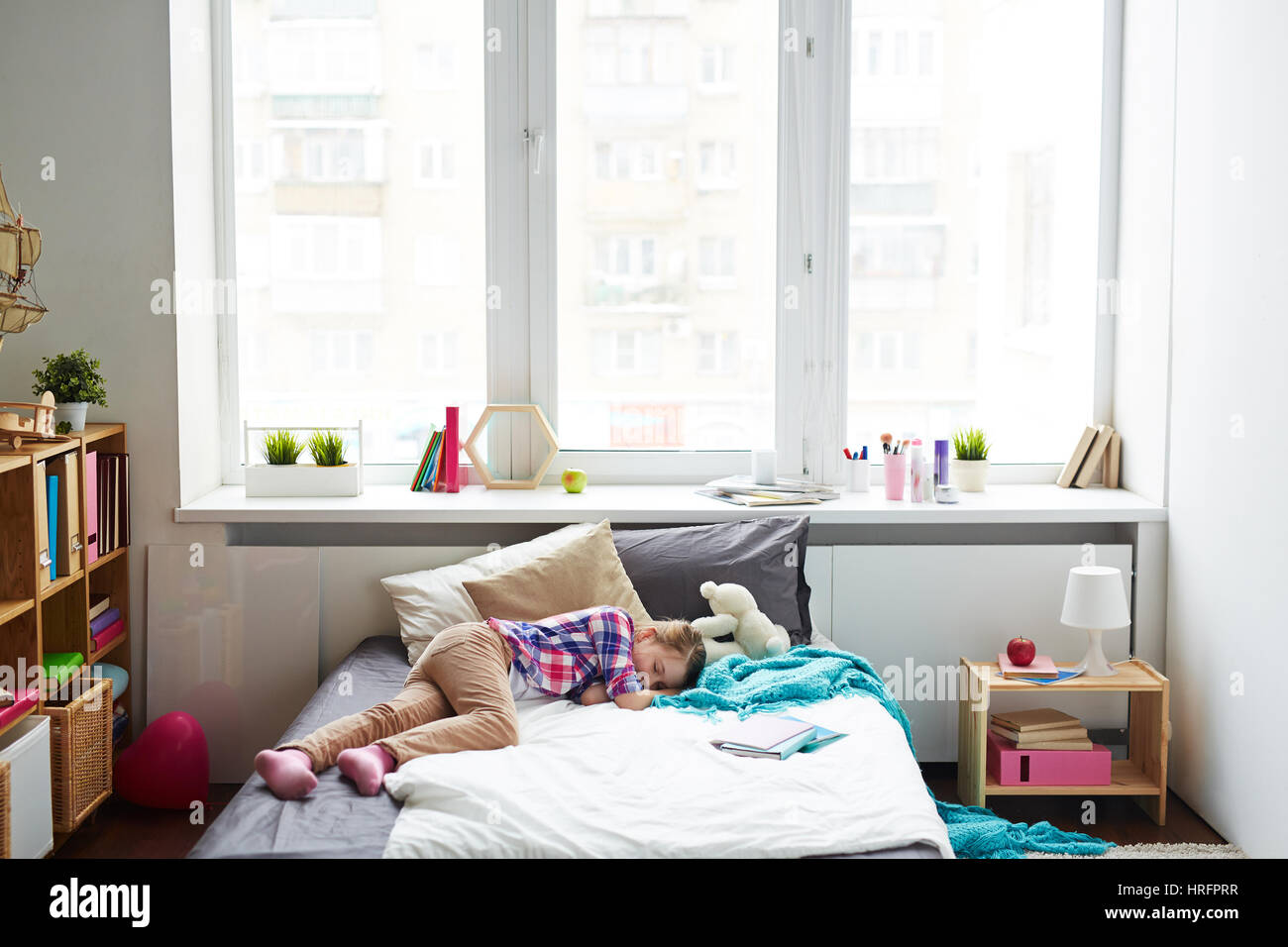 Little girl having a nap on her soft bed in bright modern room with ...