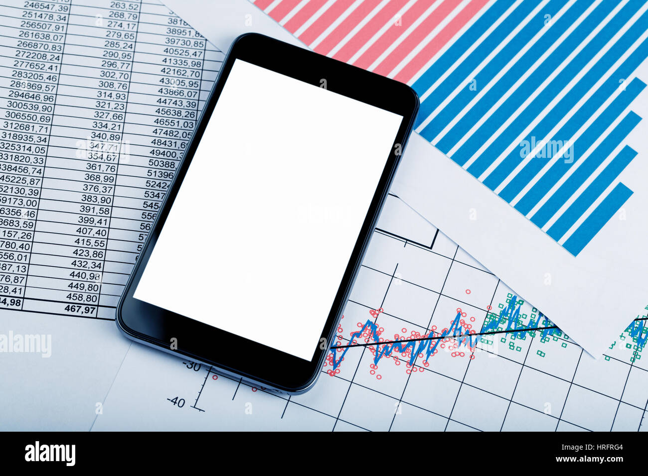 Smartphone on pile of papers and graphs Stock Photo - Alamy