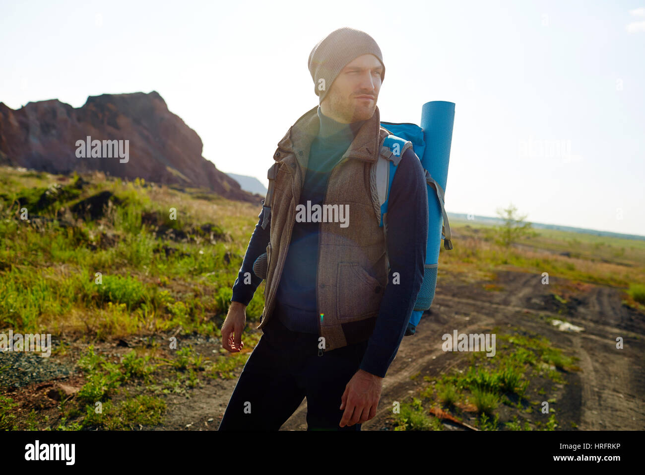 Model shot in with lens flare : adventurous handsome hiker wearing ...